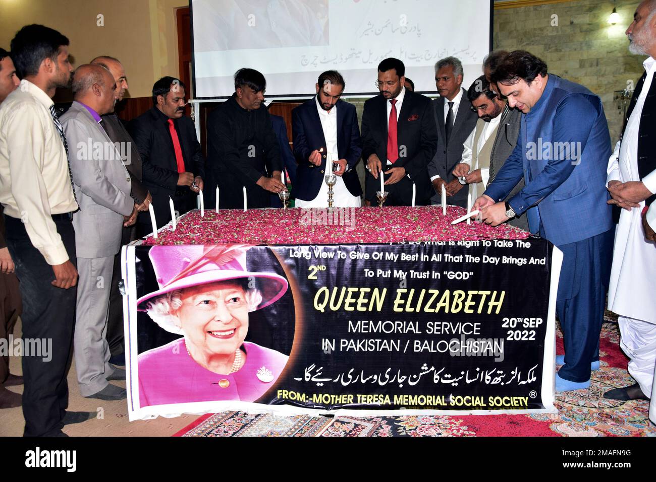 A portrait of the late Queen Elizabeth II is on display as people pay ...