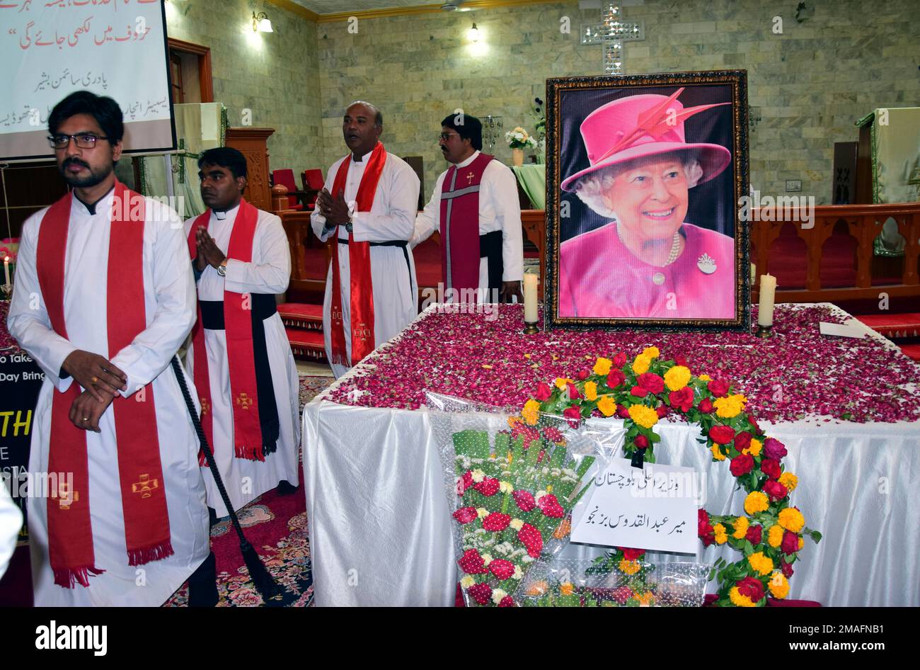 A portrait of the late Queen Elizabeth II is on display as people pay ...