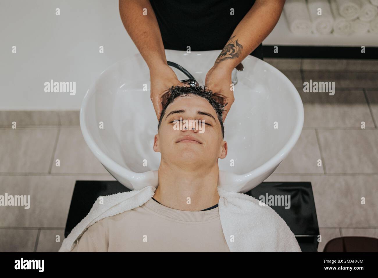 Front shoot Barber hands washing hair of his client Stock Photo - Alamy