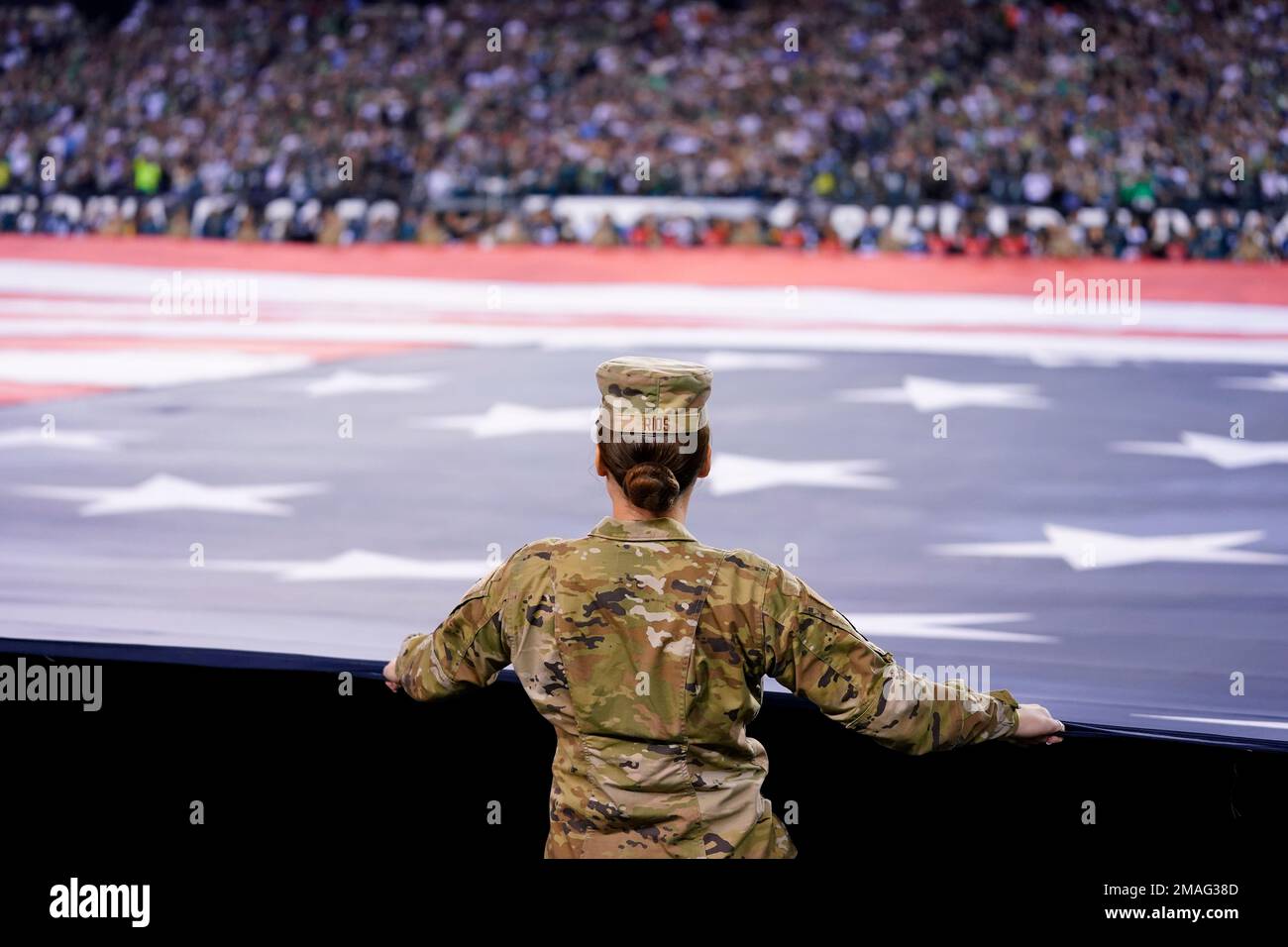 A military serviceman holds the flag during the national anthem before ...