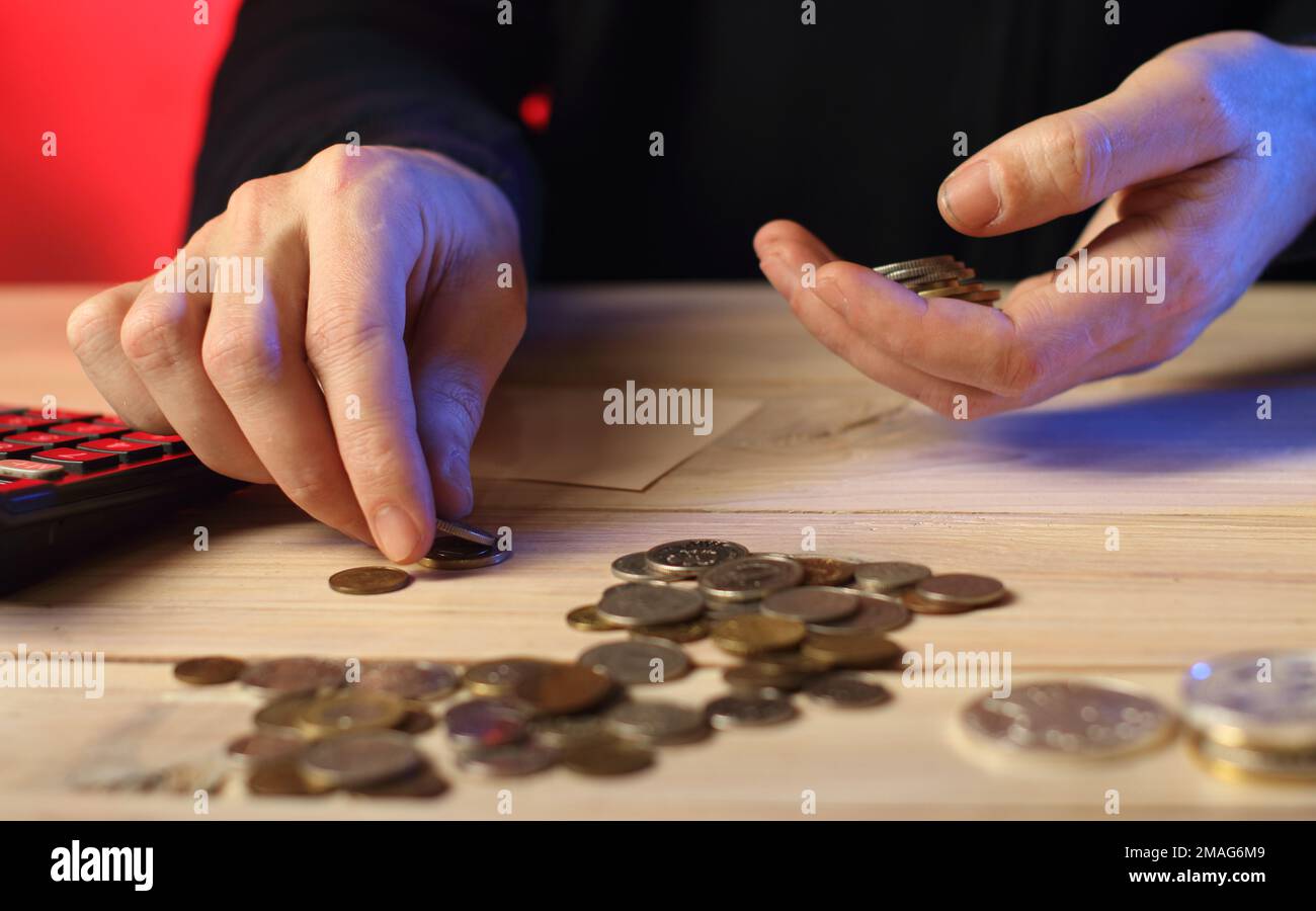 counting coins by a person on a table next to a piece of paper with a ...
