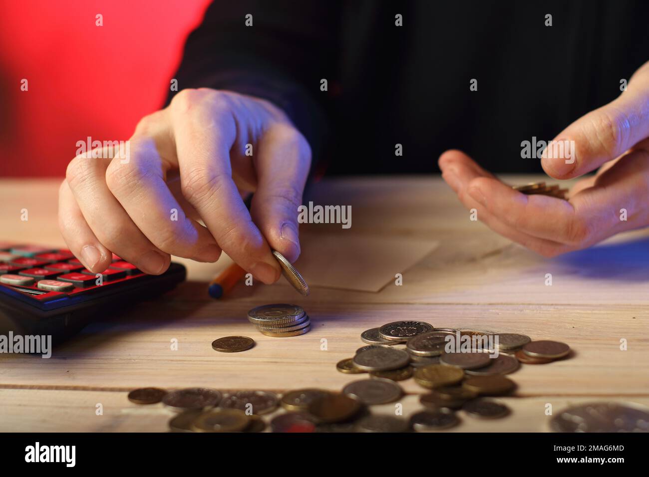 counting coins by a person on a table next to a piece of paper with a ...