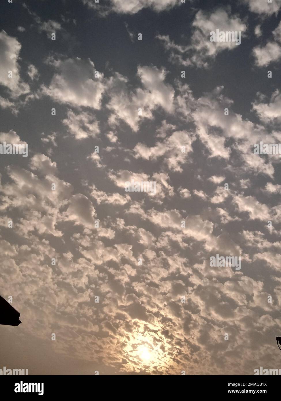 A vertical closeup of the sun on a cloudy sky Stock Photo - Alamy