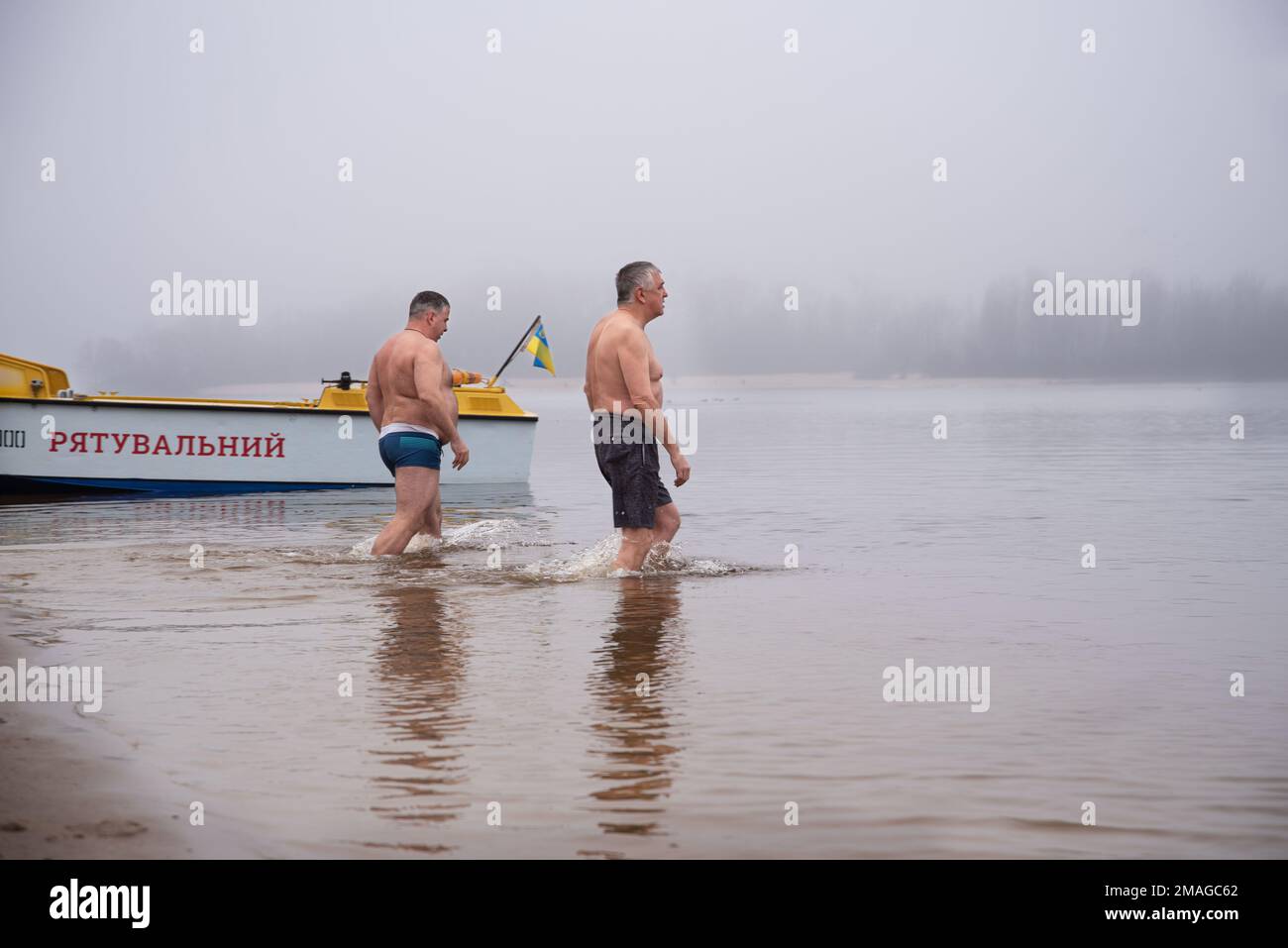 Two men walk into Chertoriya river in Kyiv to celebrate the Orthodox ...