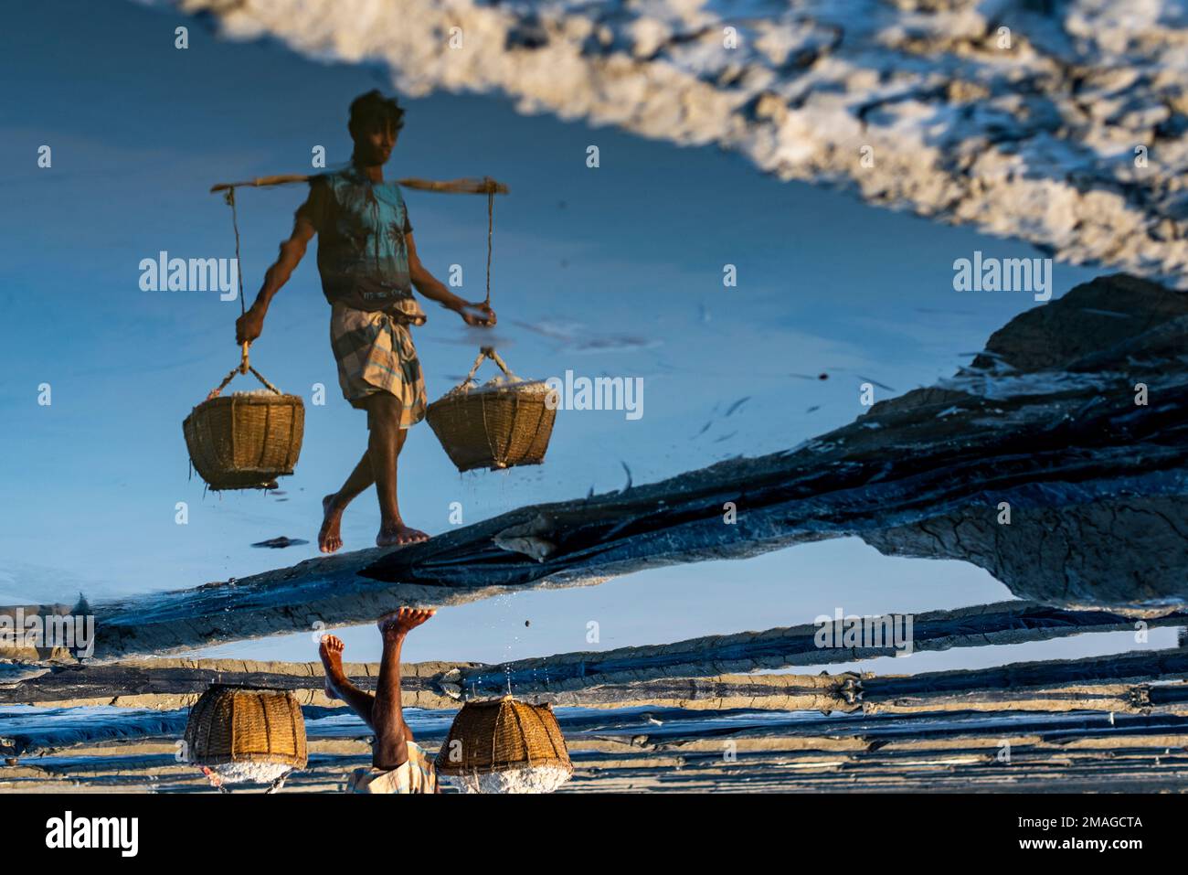 A farmer unloads raw salt at salt field yard in Chittagong, Bangladesh ...