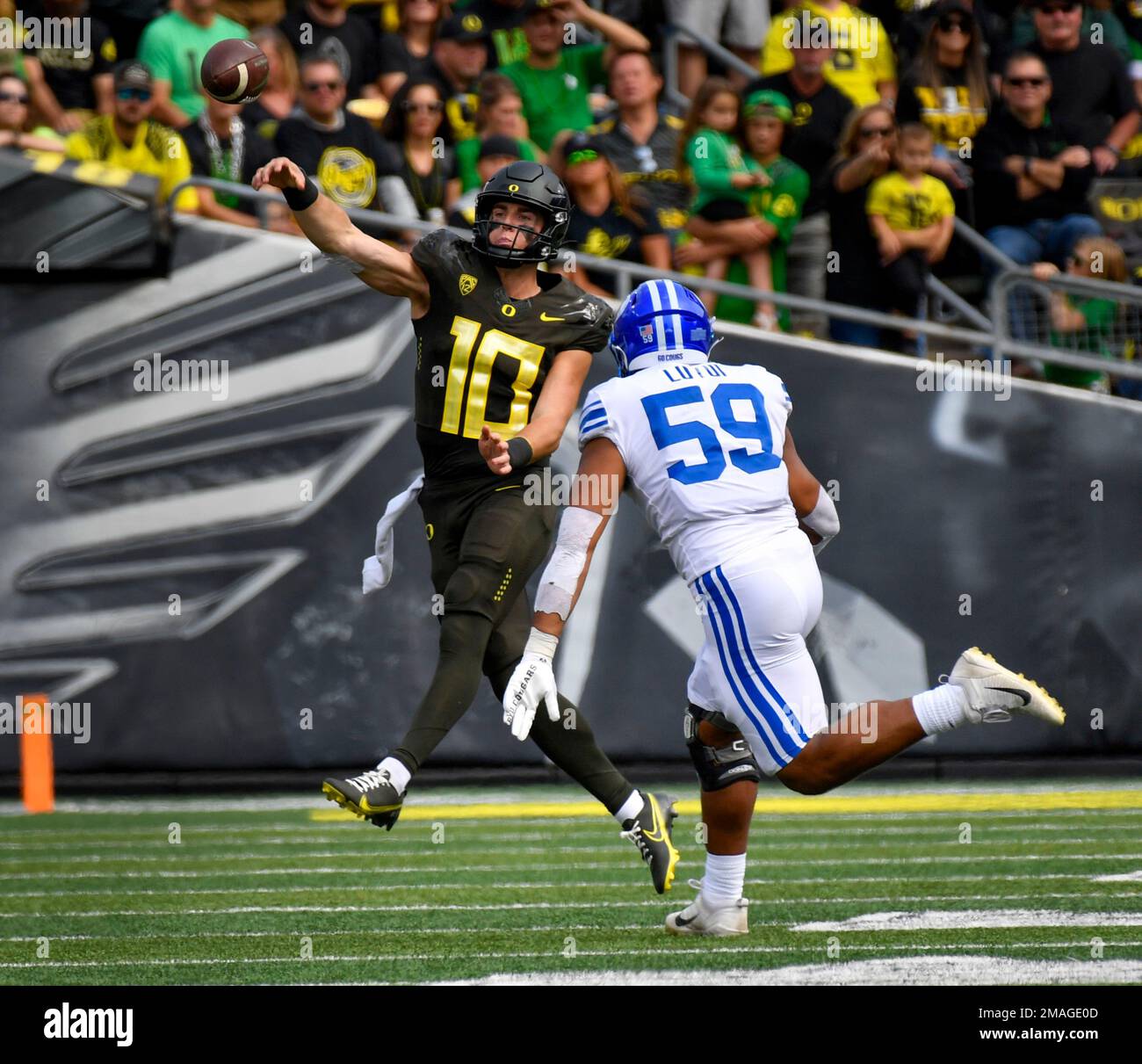 Oregon quarterback Bo Nix (10) throws as BYU defensive lineman Logan ...