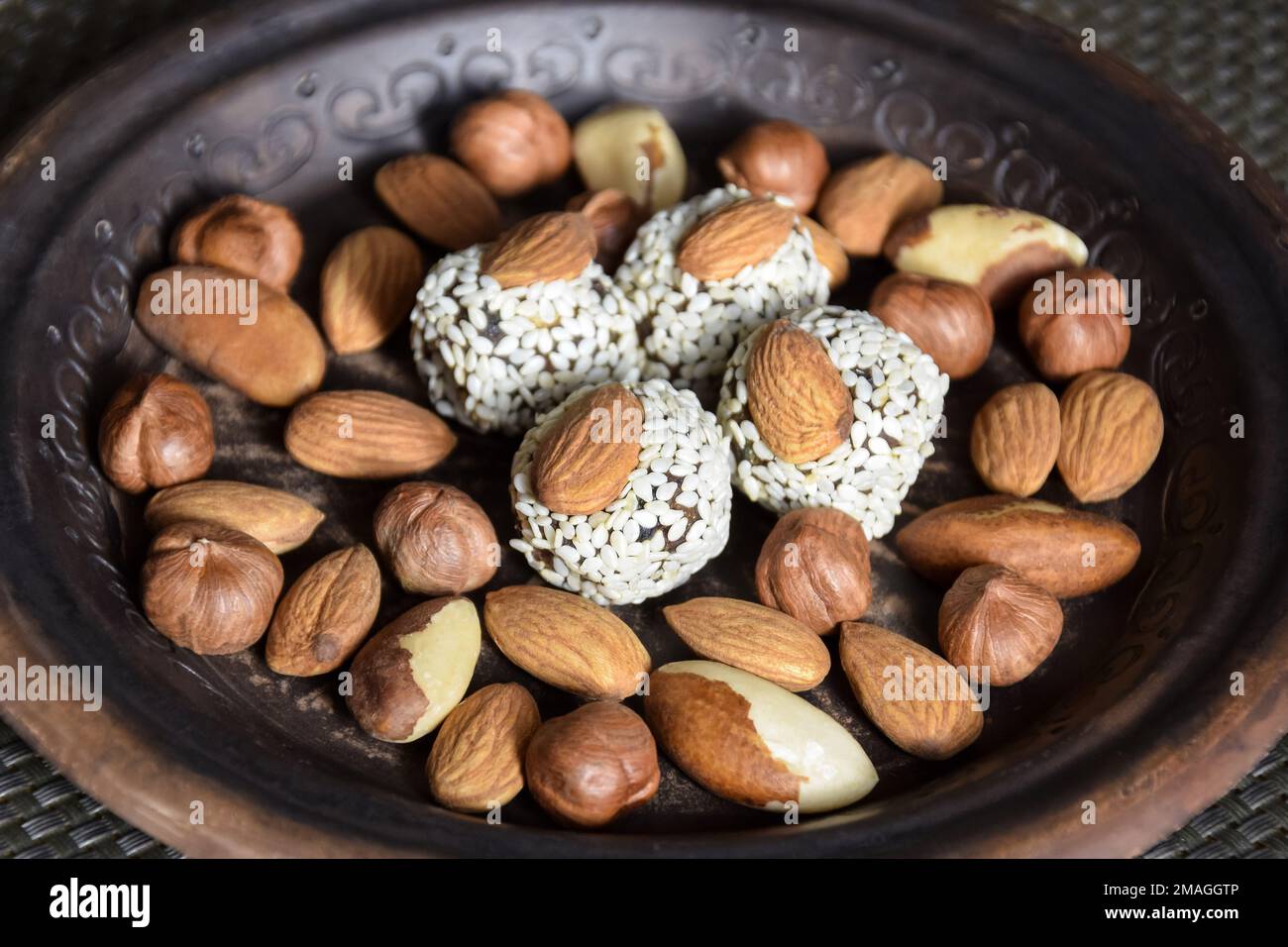 Various nuts are in brown handmade clay plate. Almonds, Hazelnuts ...