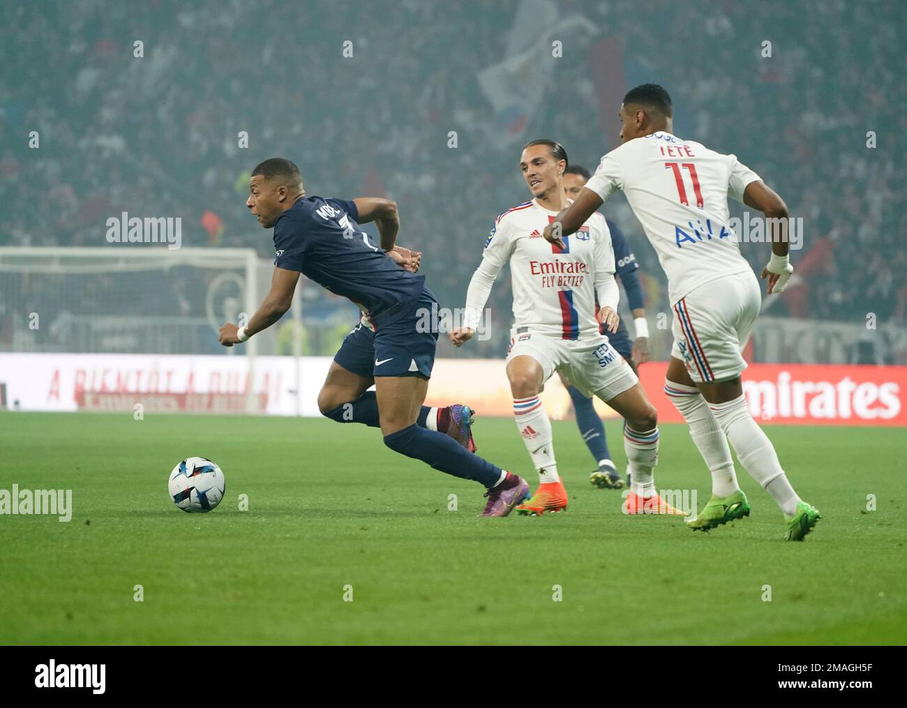 PSG's Kylian Mbappe, left, control the ball while Lyon's Malo Gusto ...