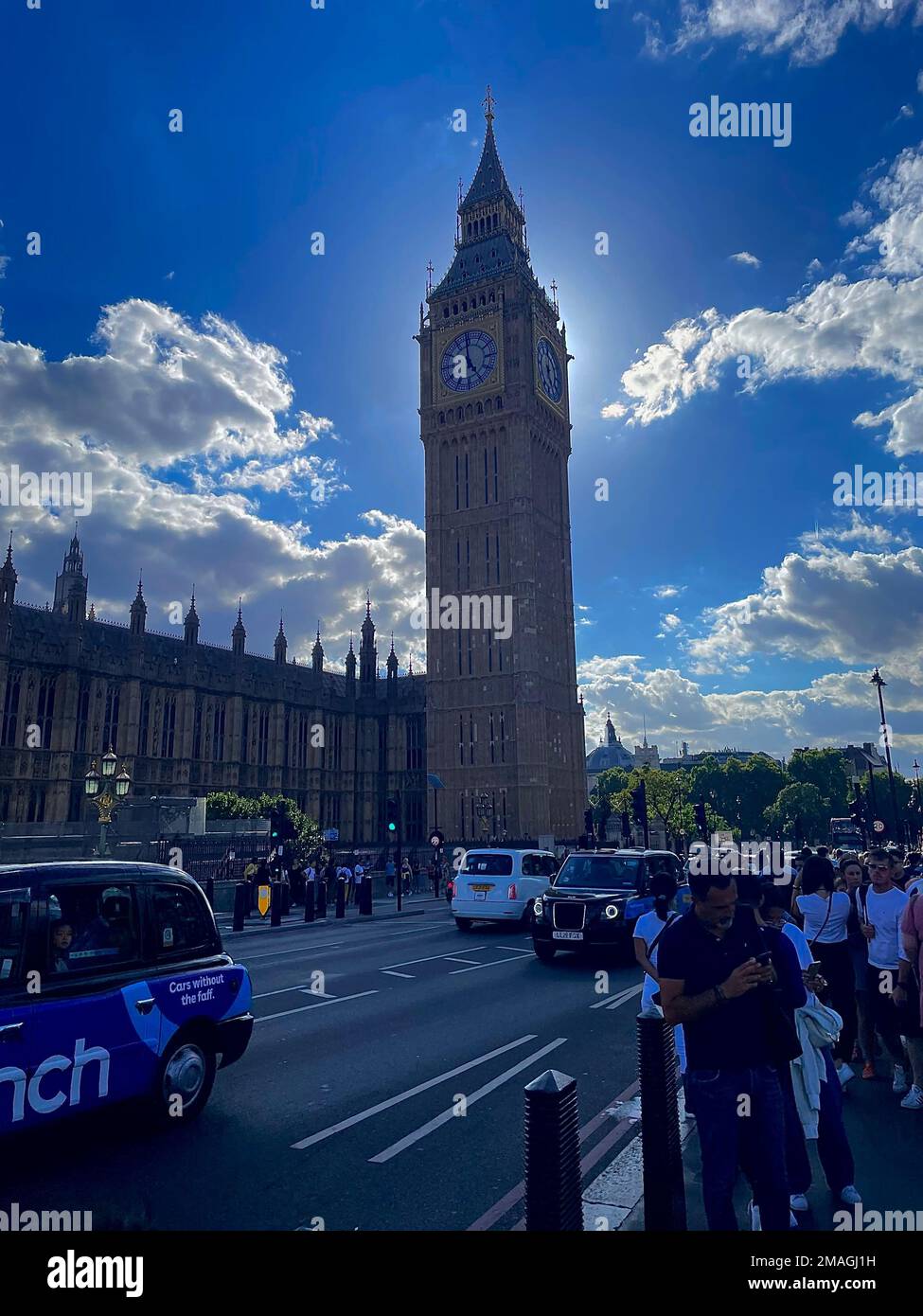 A vertical of a crowd of people around the Big Ben against the shiny ...