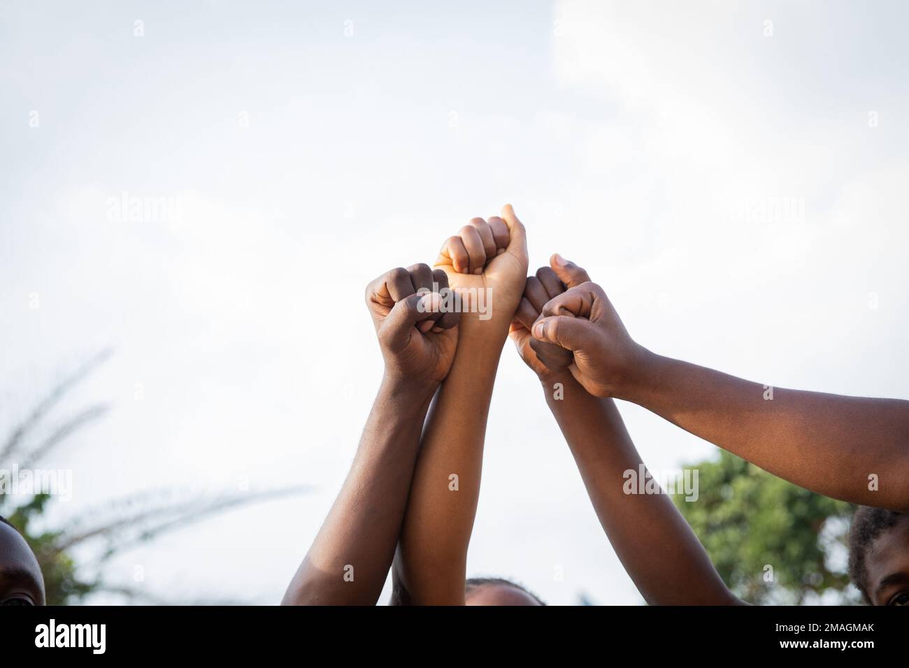 Four fists of African people united in sky, photo with copy space above ...