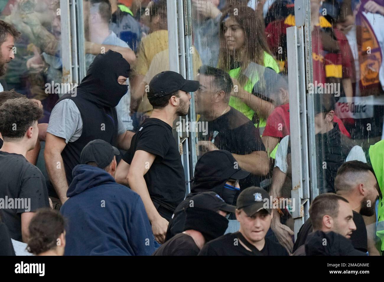 Atalanta and Roma supporters face each others divided by a glass during ...
