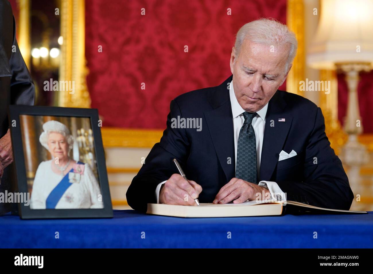 President Joe Biden signs a book of condolence at Lancaster House in ...