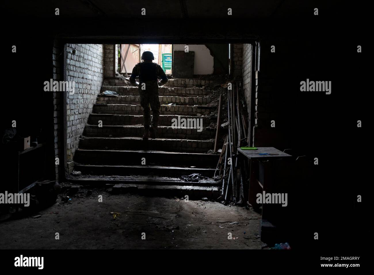 An Ukrainian serviceman walks out of a basement which, according to ...