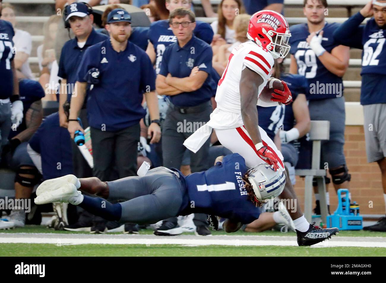 Louisiana-Lafayette running back Jacob Kibodi, right, is tackled by ...