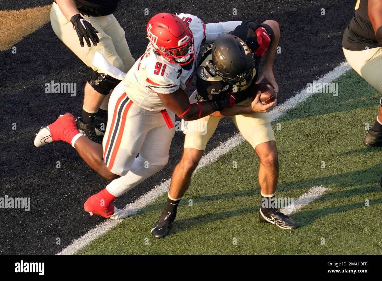 Wake Forest quarterback Sam Hartman (10) is sacked by Liberty defensive ...