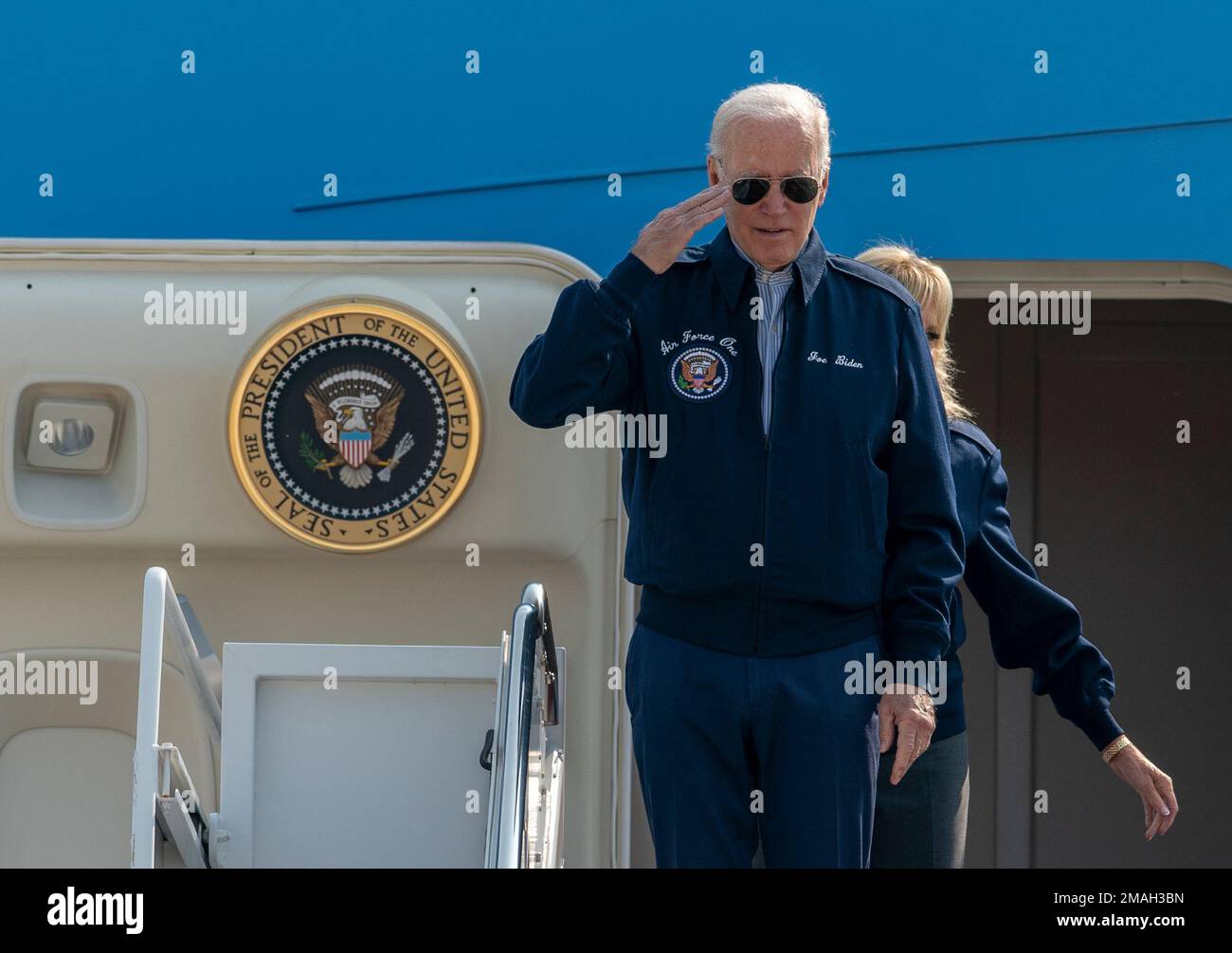 President Joe Biden returns a salute as first lady Jill Biden watches ...