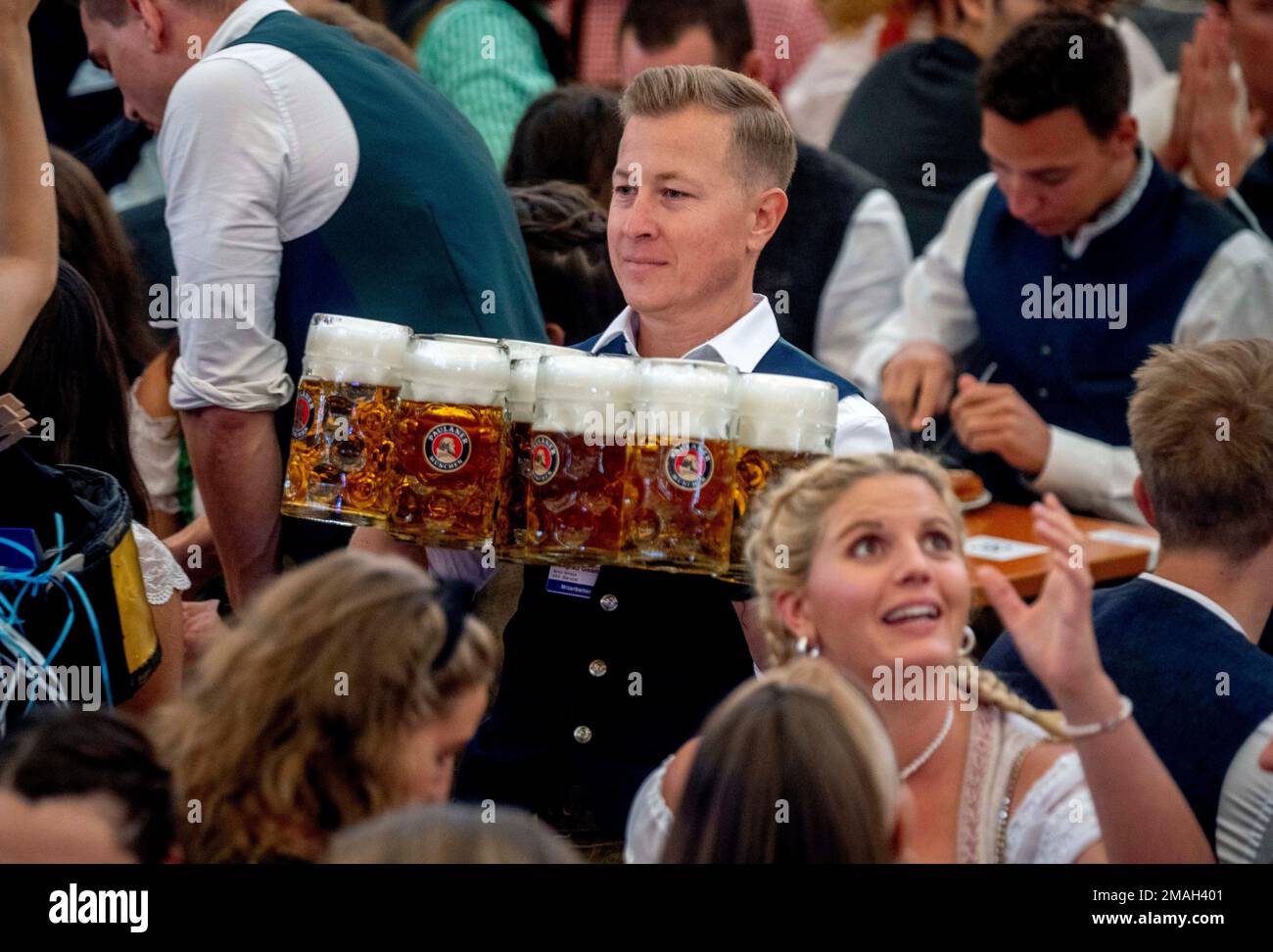 A waiter carries beer in one of the beer tents on the opening day of ...