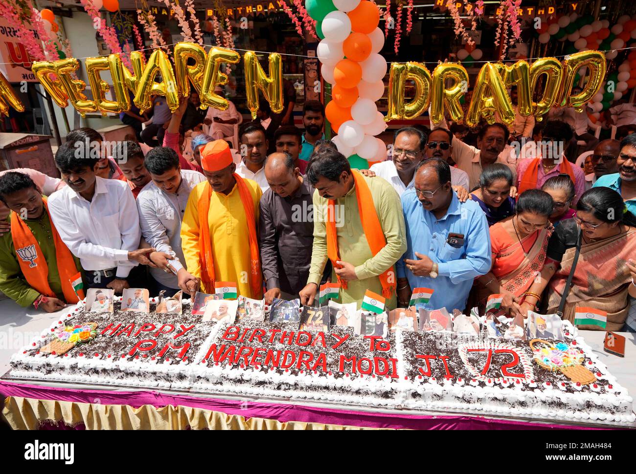 Supporters of Prime Minister Narendra Modi cut a cake to celebrate his ...
