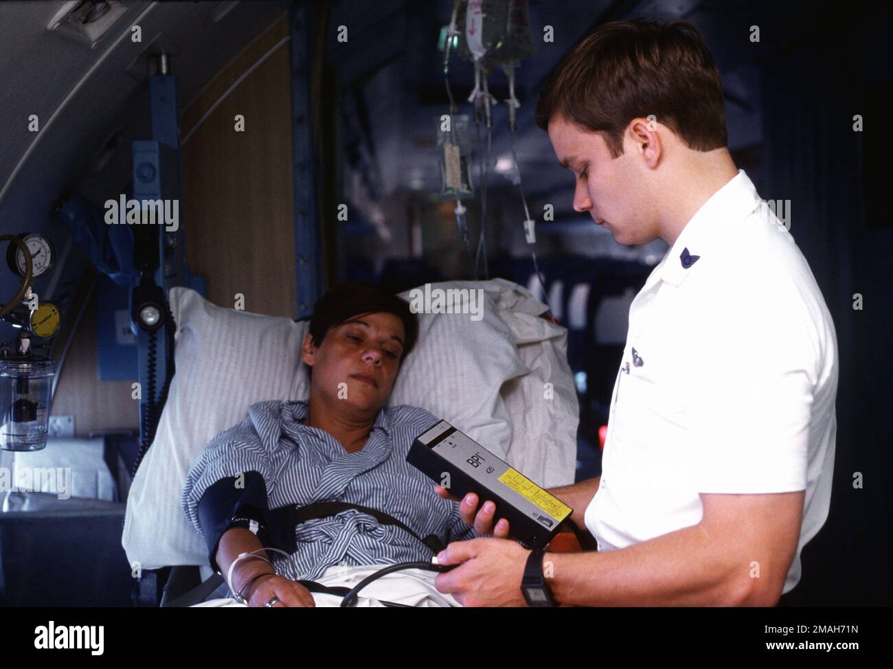 An enlisted medical technician takes the blood pressure of a patient ...