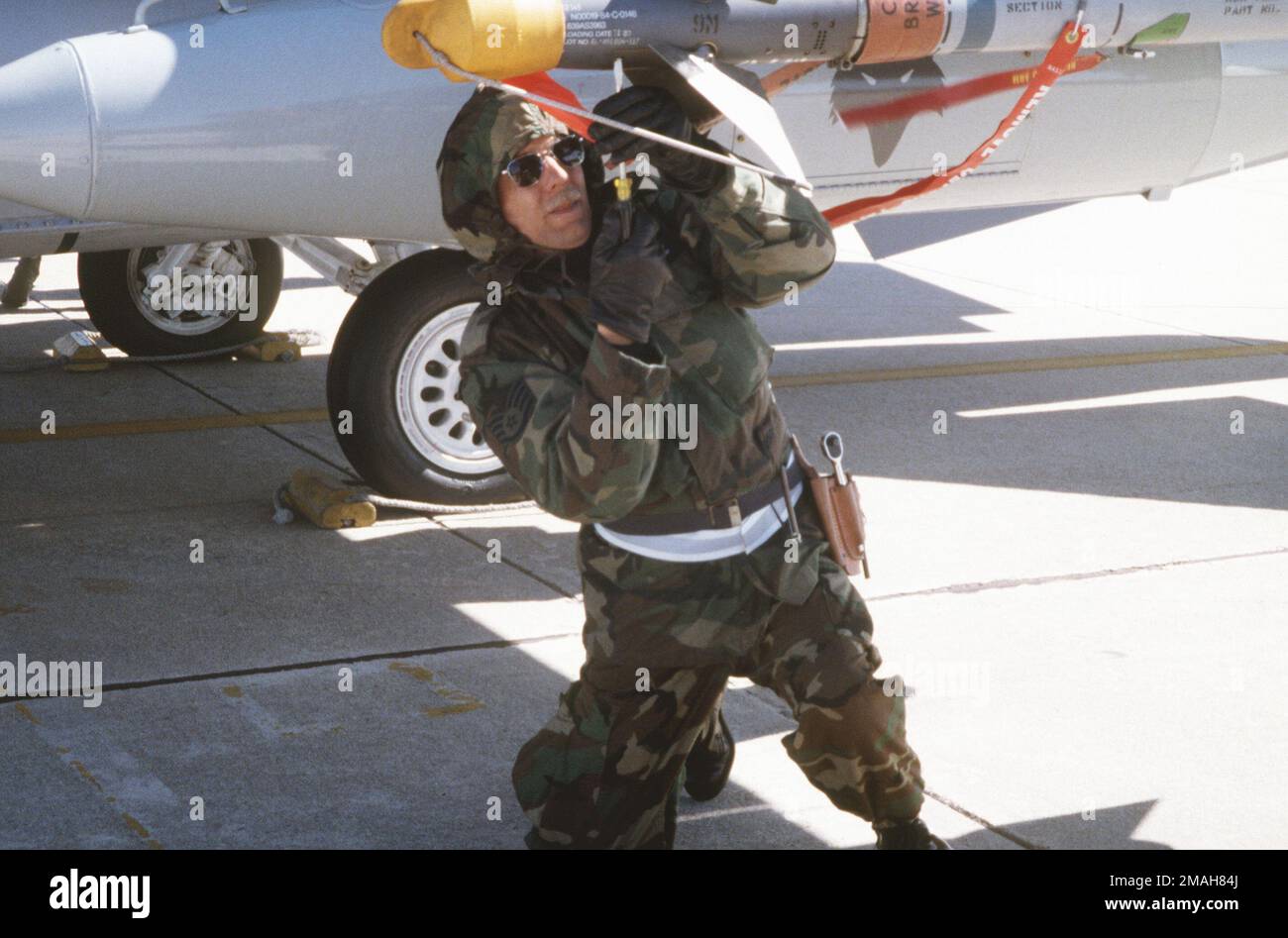 A munitions mechanic works on the missile armament of an F-16 Fighting ...