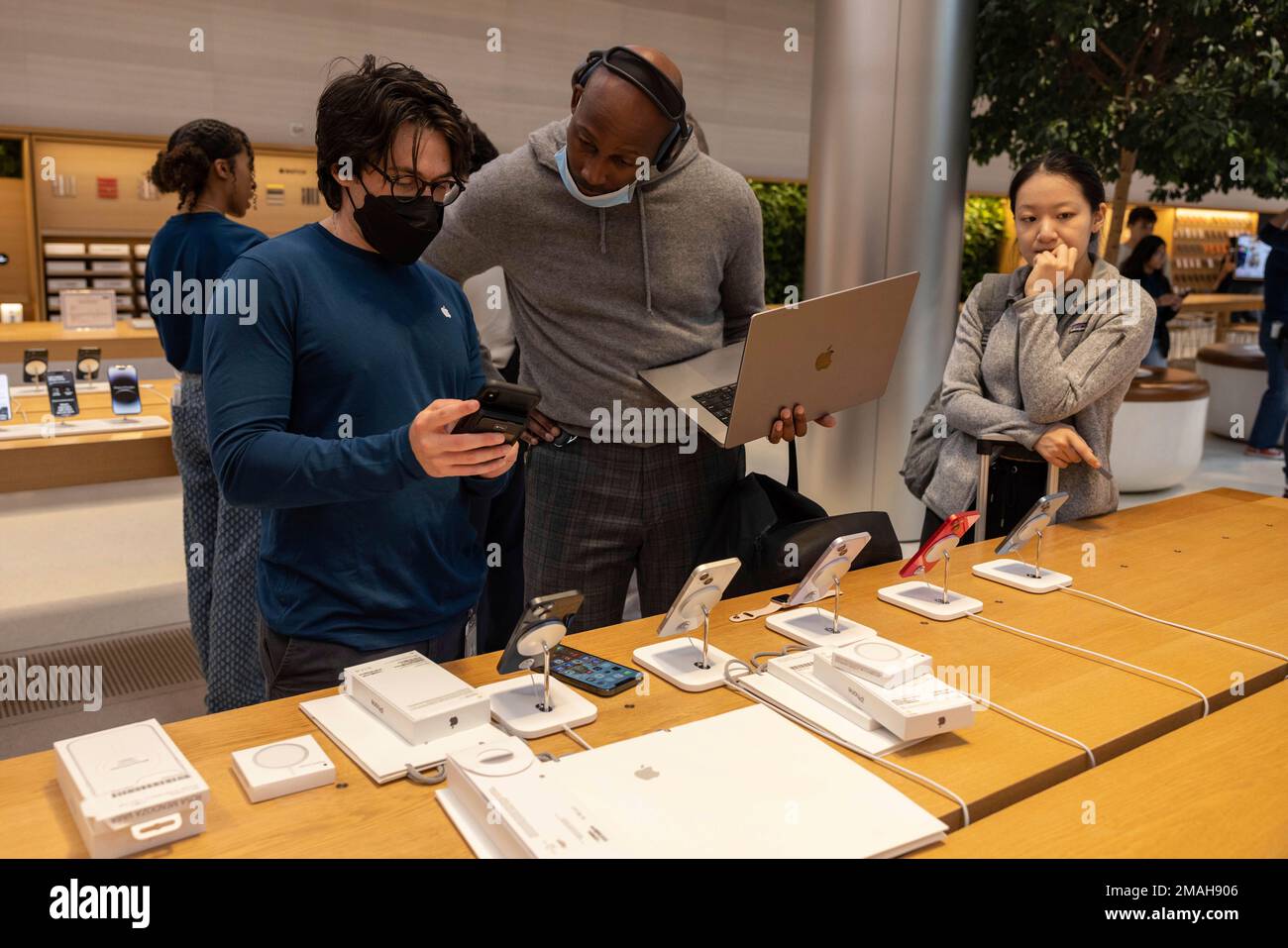 Apple employee talks with a customer at the Apple Fifth Avenue store ...