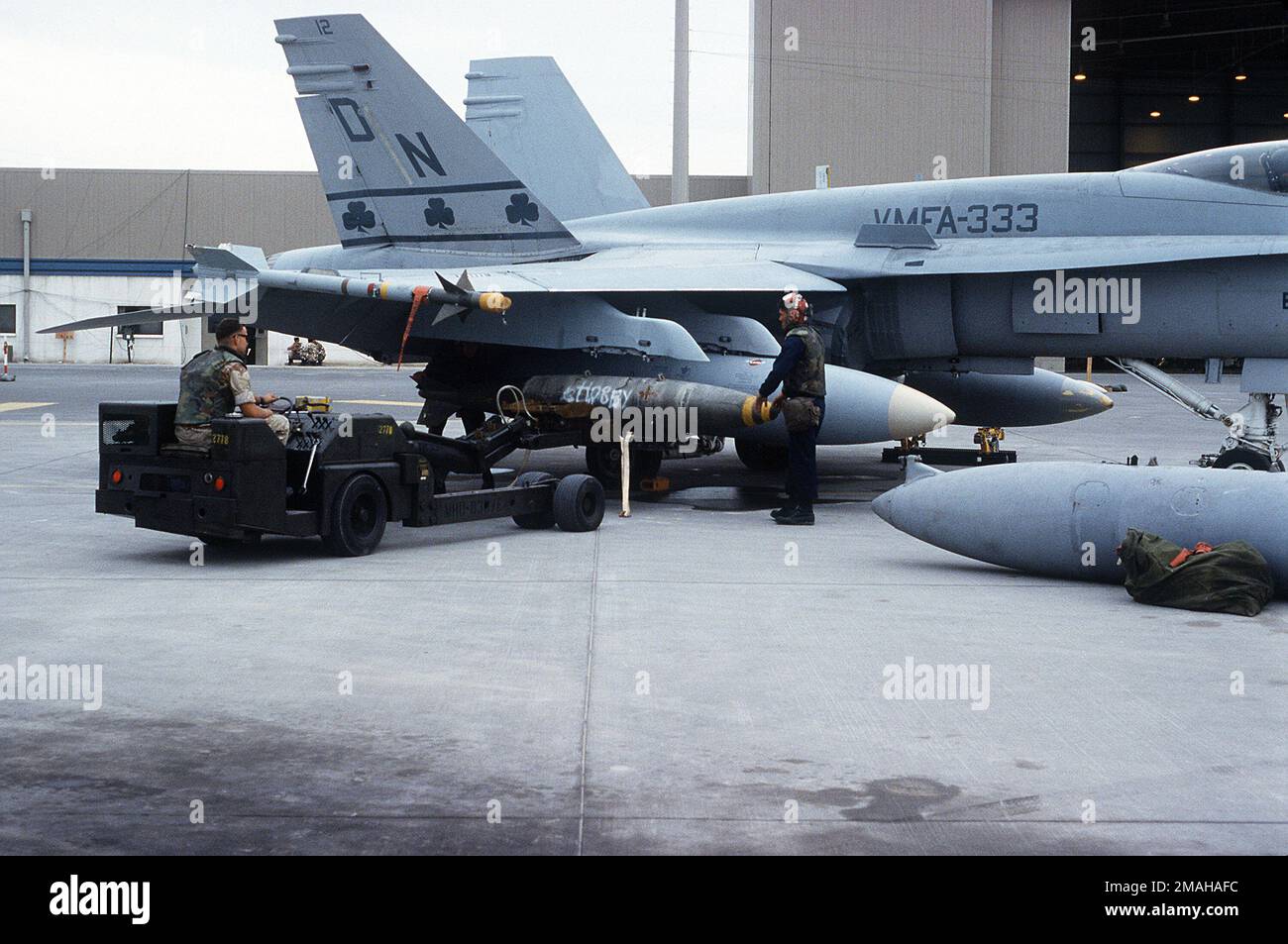 U.S. Marines load a Mark 84 2,000-pound bomb under the wing of an F/A ...