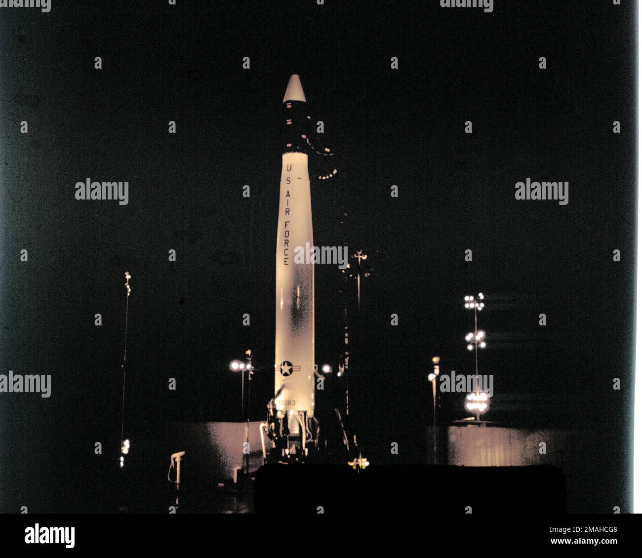 Night scene of a Thor missile, a standard launch vehicle, as it stands ...