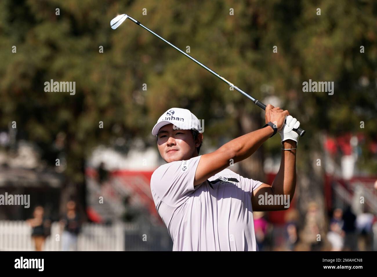 S.H. Kim, of South Korea, follows his shot from off the 18th fairway of ...