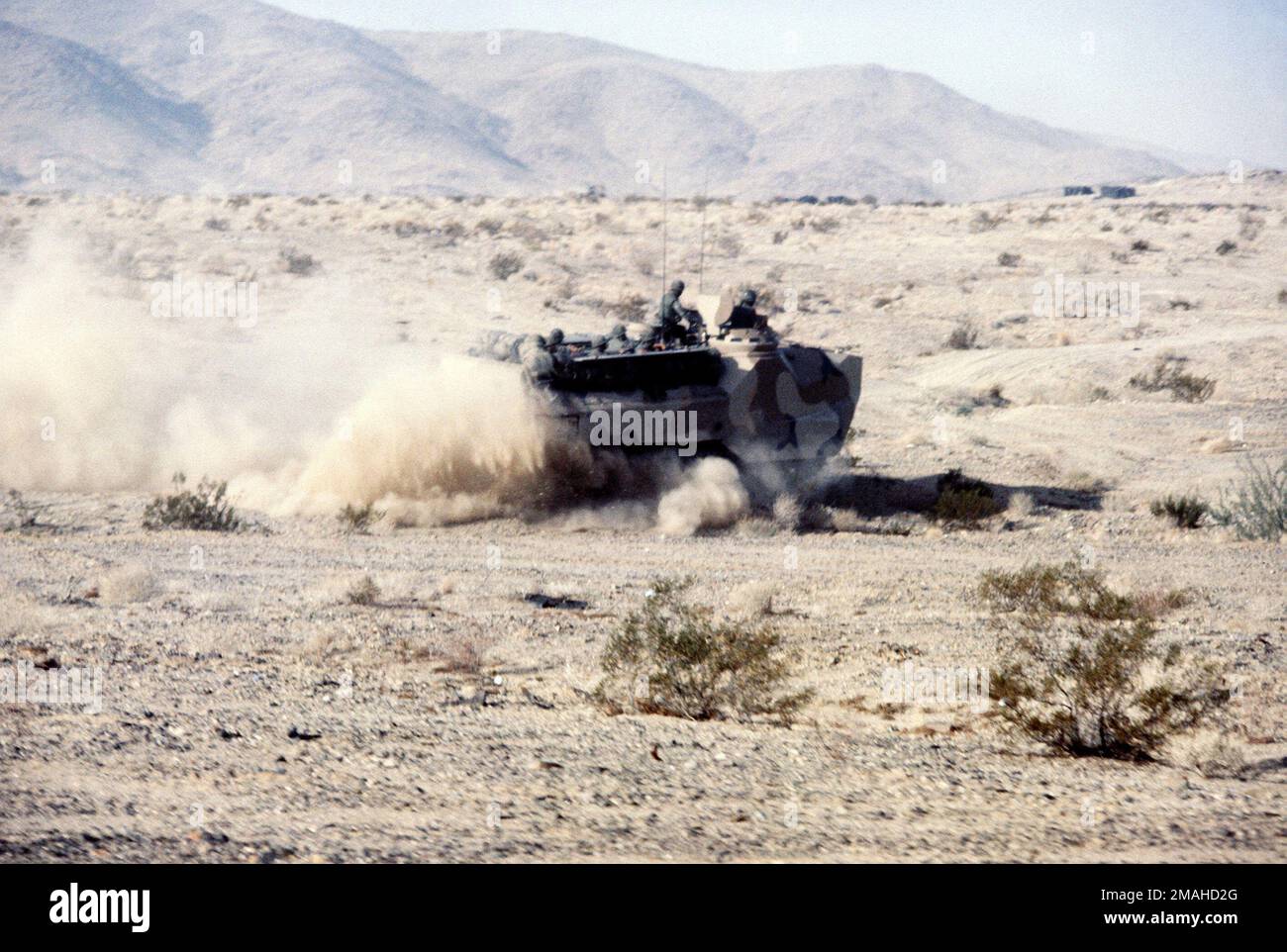 An LVTP-7 tracked landing vehicle loaded with troops speeds across the ...