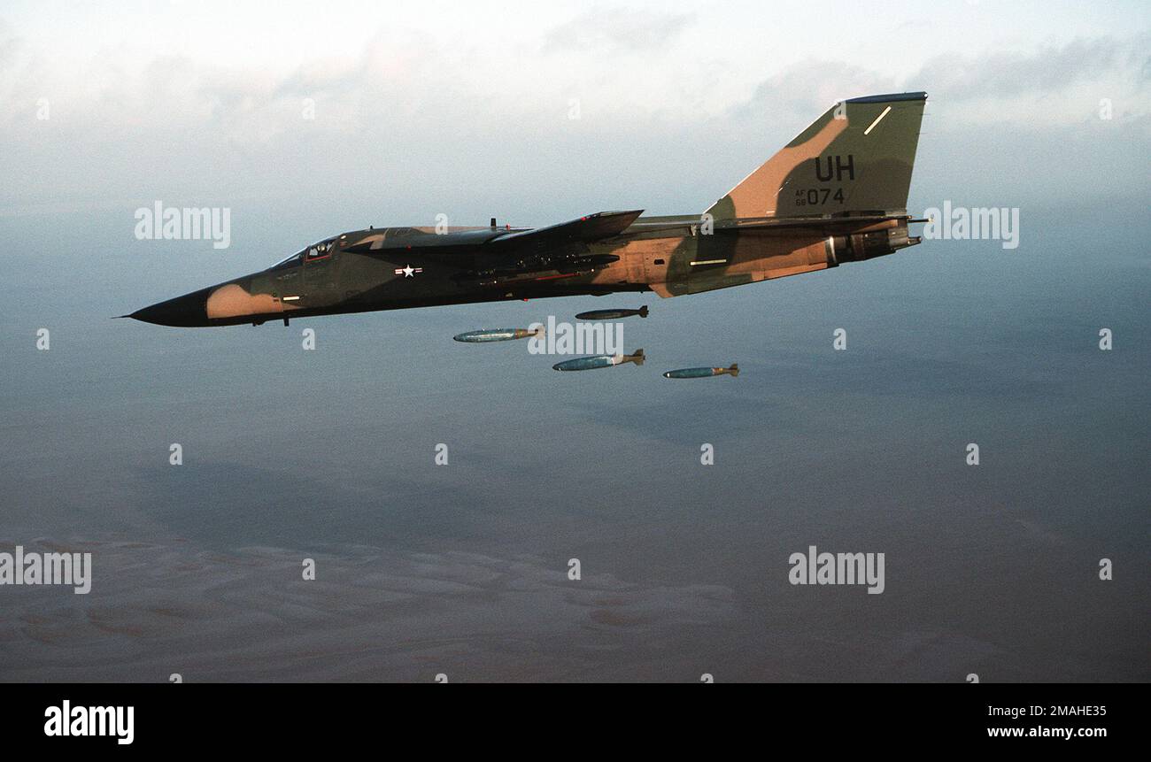 A left side air-to-air view of an F-111 aircraft dropping four bombs on ...