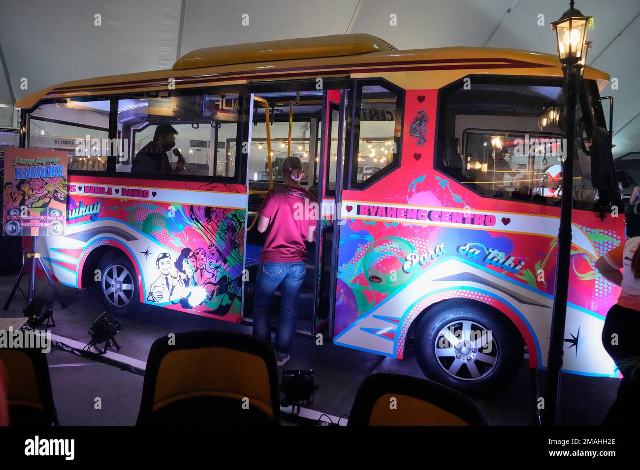 A staff tests a karaoke system inside a concept passenger vehicle ...