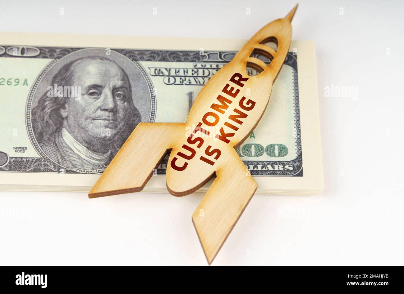 Business concept. On the dollars lies a wooden model of a rocket with ...