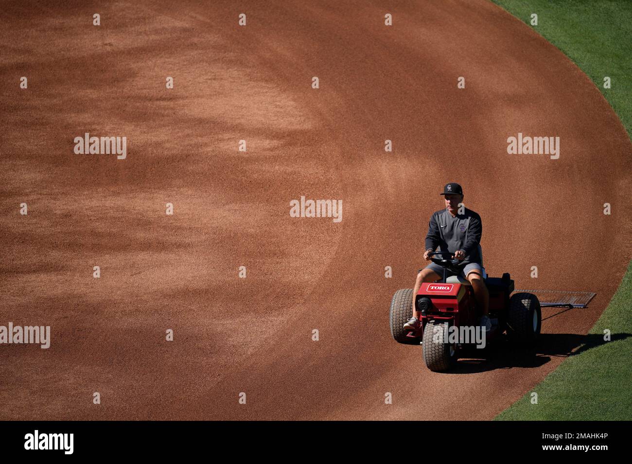 Head groundskeeper Mark Razum drags the skin of the infield before a ...