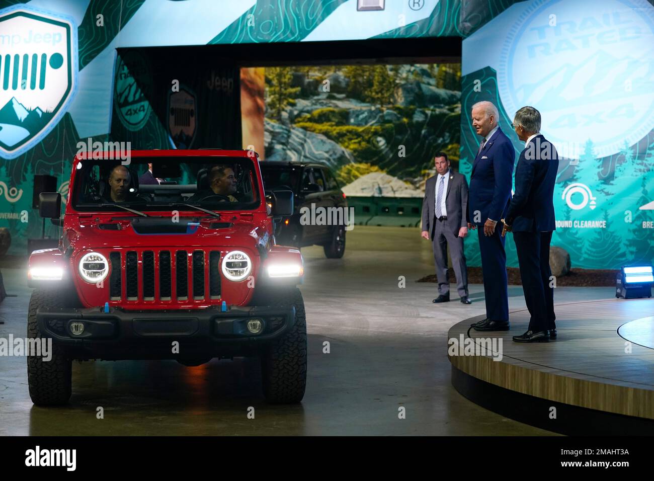 President Joe Biden looks at a Jeep as he stands with Carlos Tavares ...