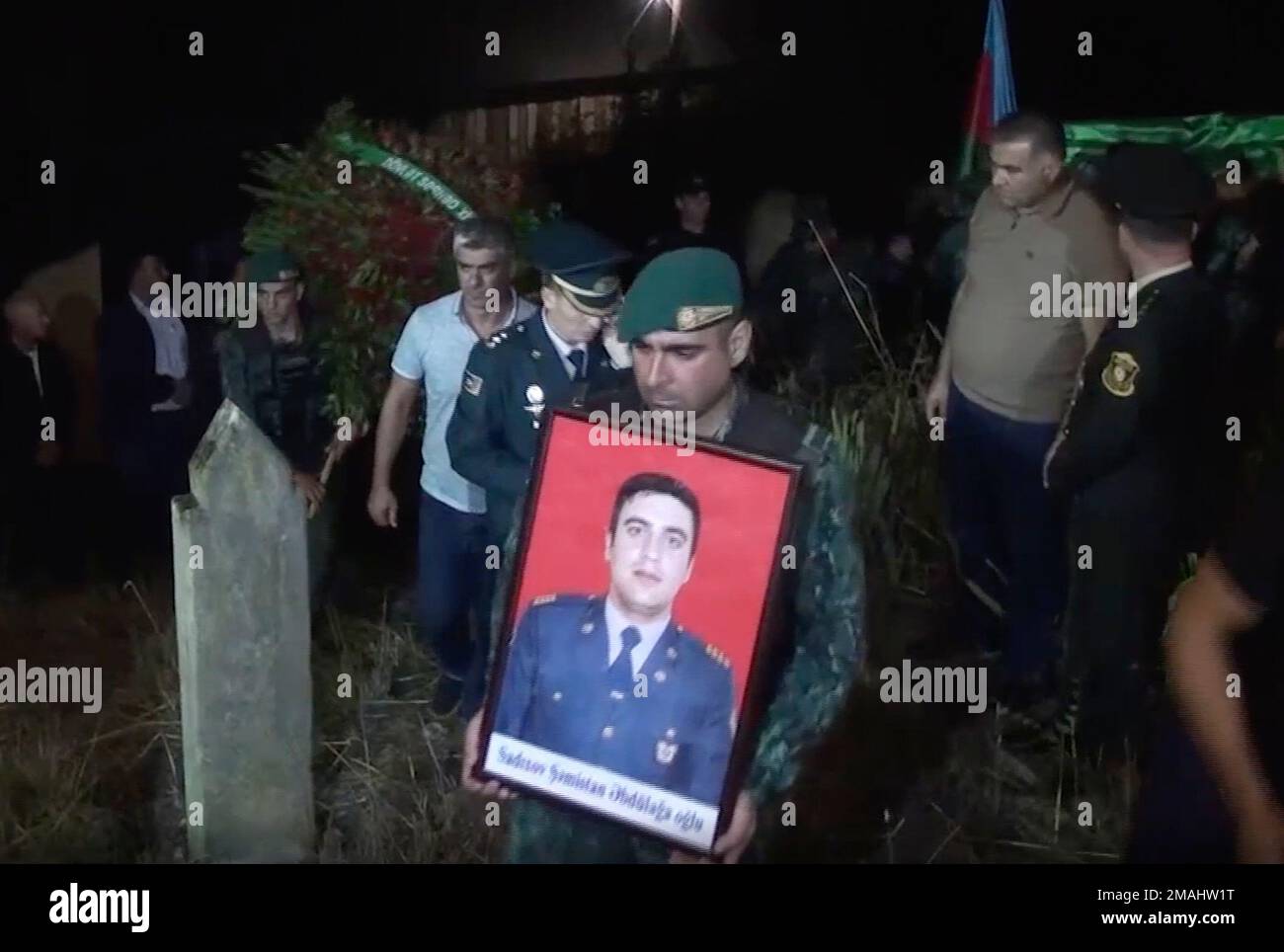 In this image taken from video, a serviceman carries a portrait of ...
