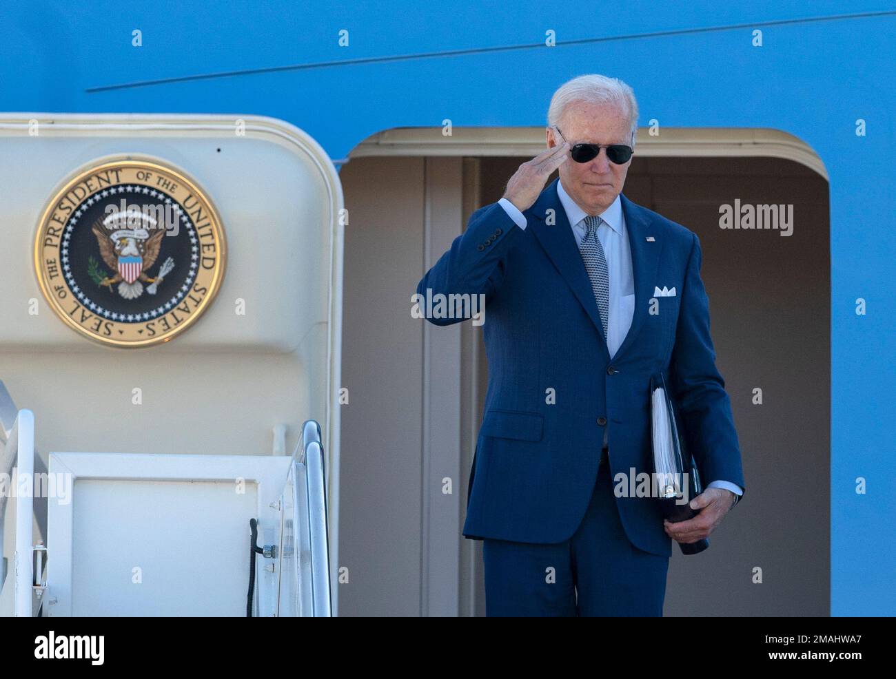 President Joe Biden returns a salute as he boards Air Force One ...