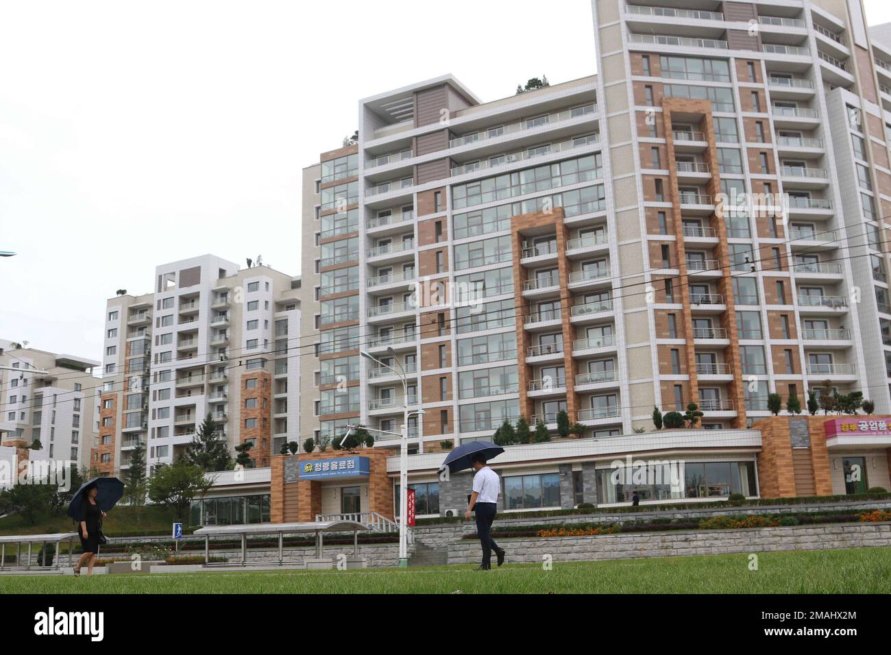 People walk by apartment buildings in Pyongyang, North Korea, on ...