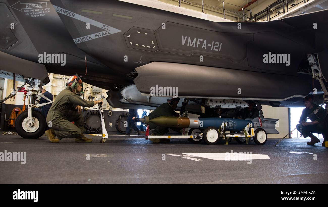 U.S. Marines with Marine Fighter Attack Squadron (VMFA) 121 load ordnance into an F-35B ...
