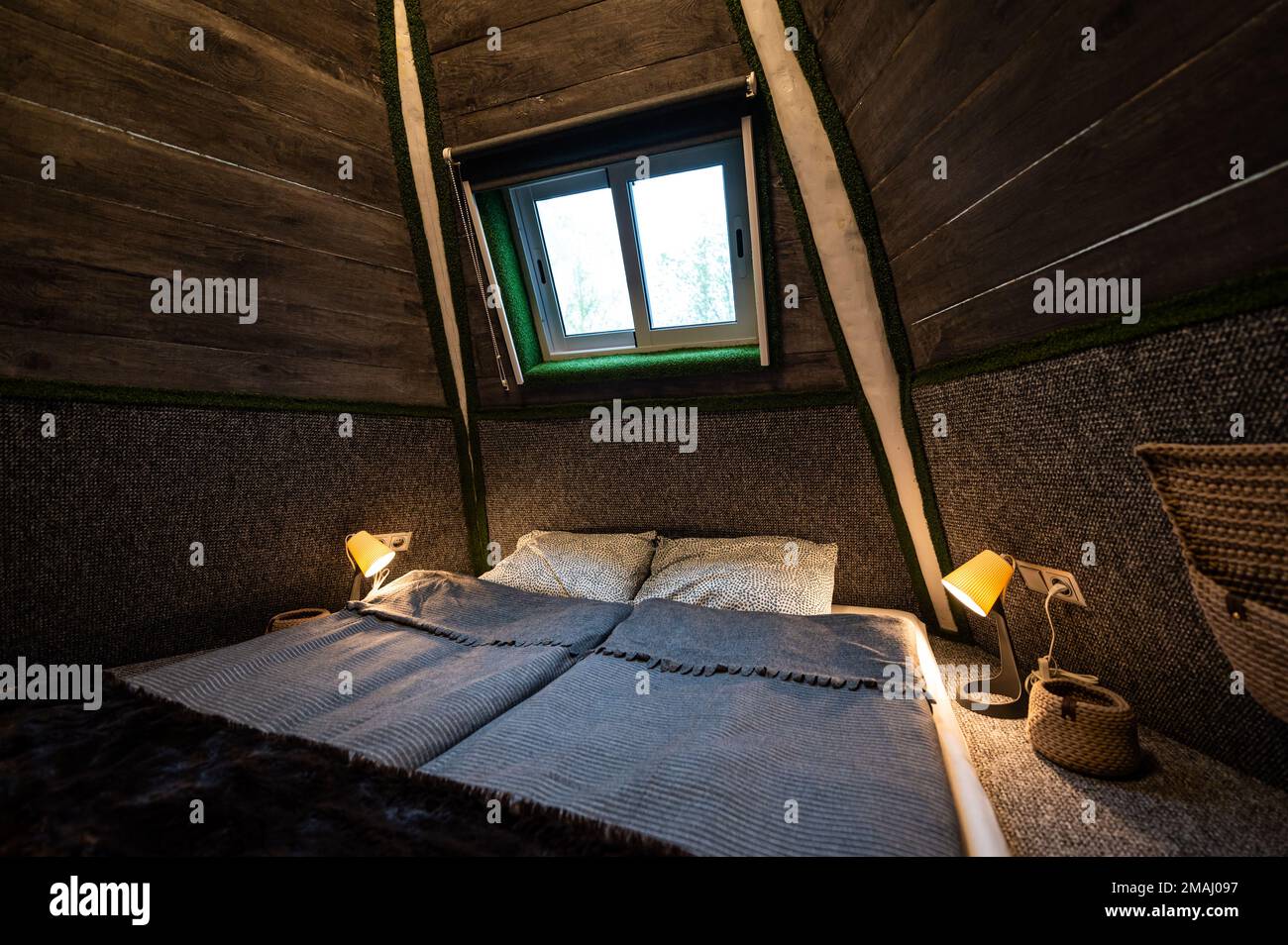 Double bed in bedroom of pyramid shape wooden cabin. Pyramid shape ...