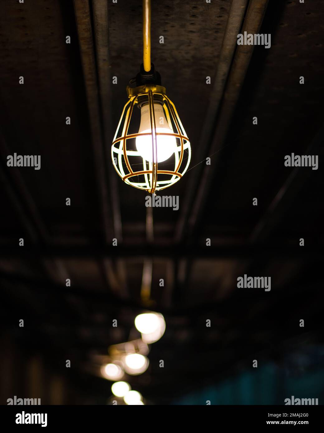 A closeup of a yellow construction light hanging from scaffolding Stock ...