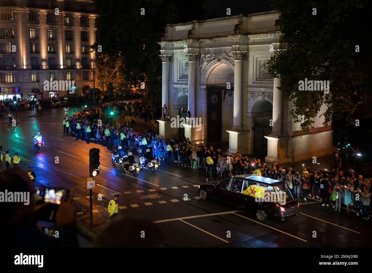 People gather near the Marble Arch as the State Hearse carrying the ...
