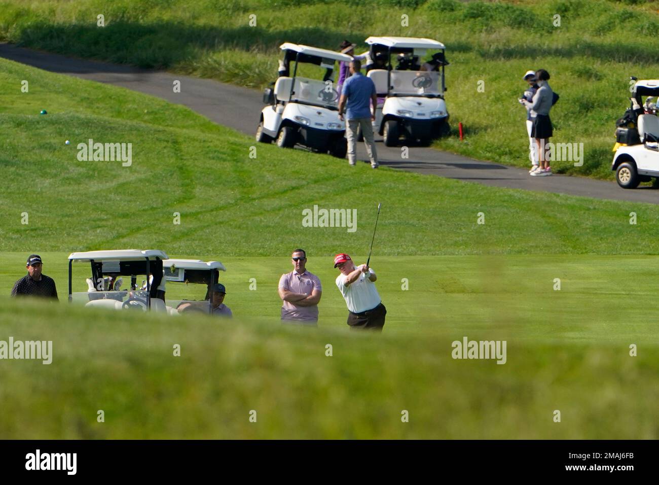 Former President Donald Trump hits a golf shot at Trump National Golf ...