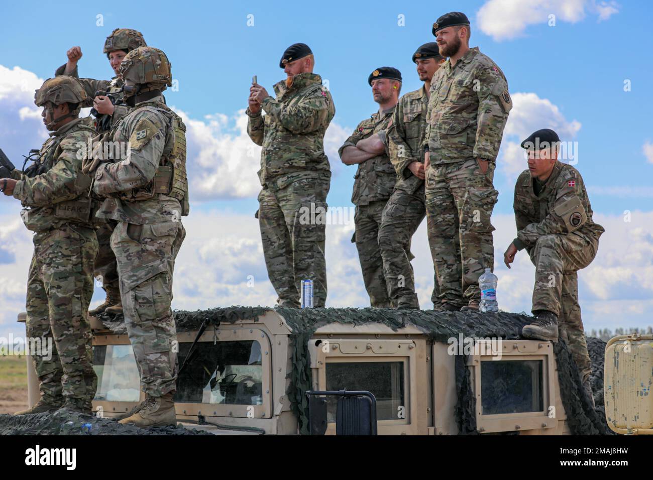 Soldiers of the Royal Danish Army watch and take photos of U.S ...