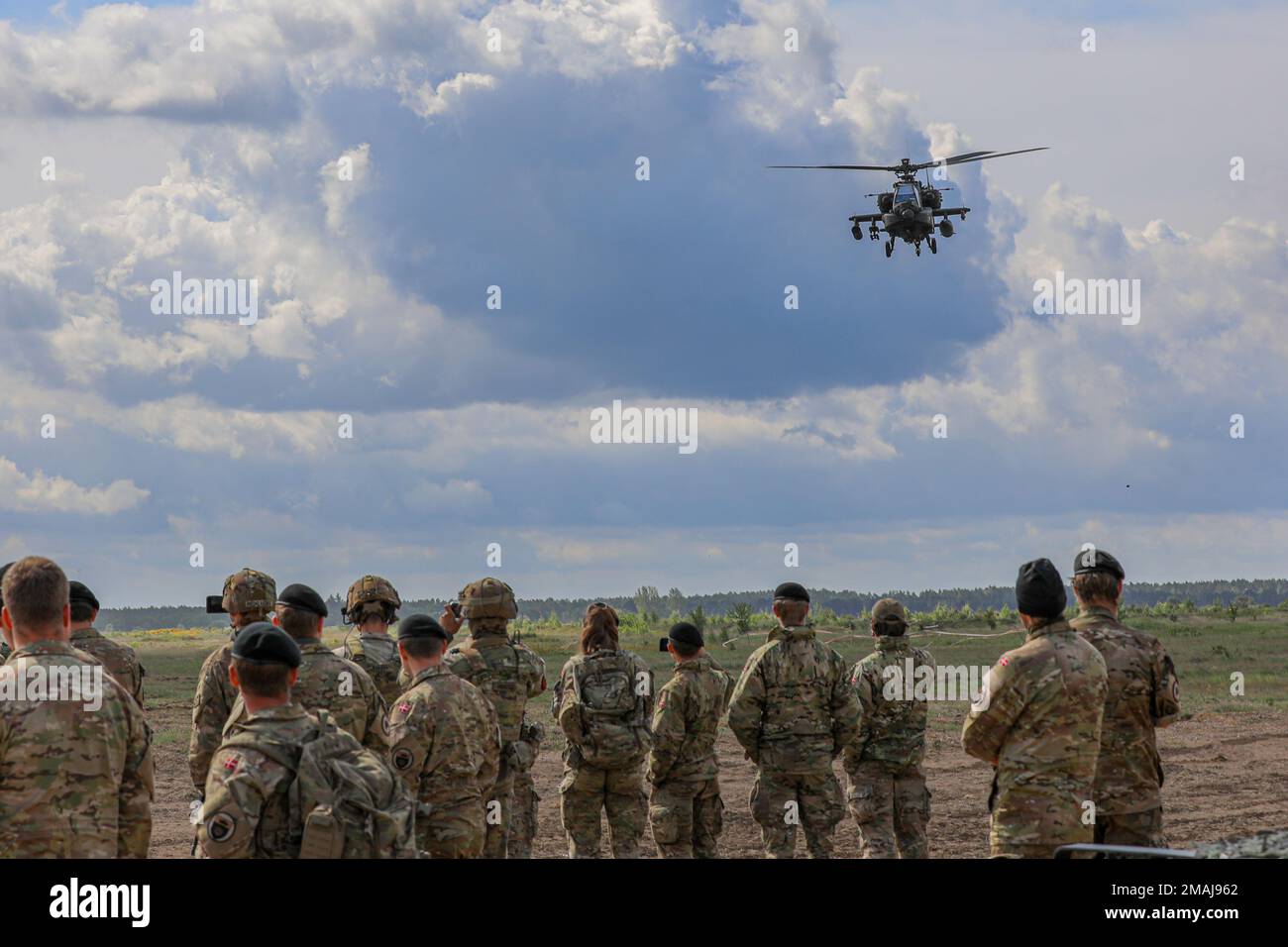 Danish and U.S. Soldiers watch as a U.S. Army AH-64E Apache Guardian ...