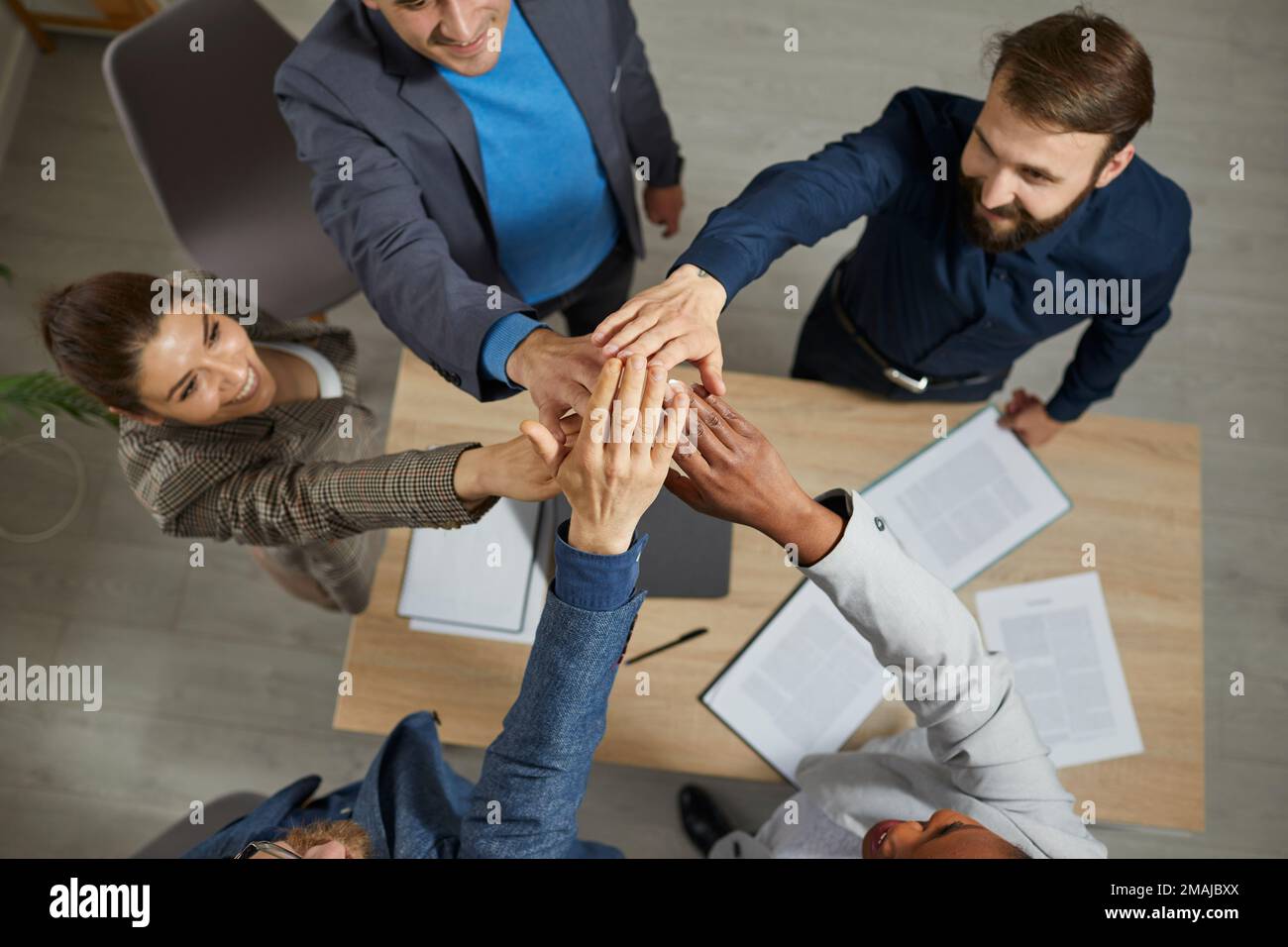 Team of happy business people joining hands after successful work ...
