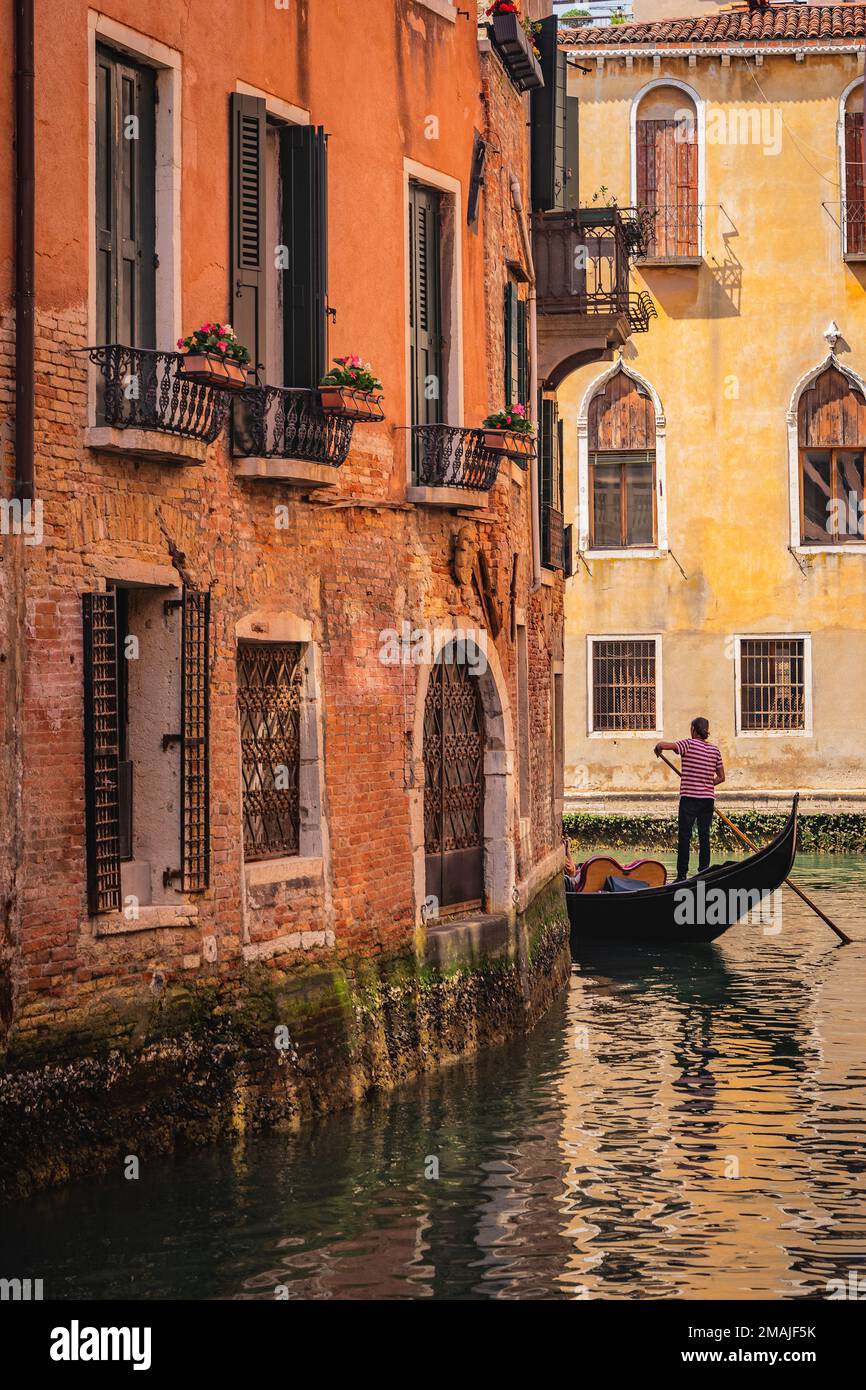 Venice with gondolier and buildings in a canel Stock Photo - Alamy