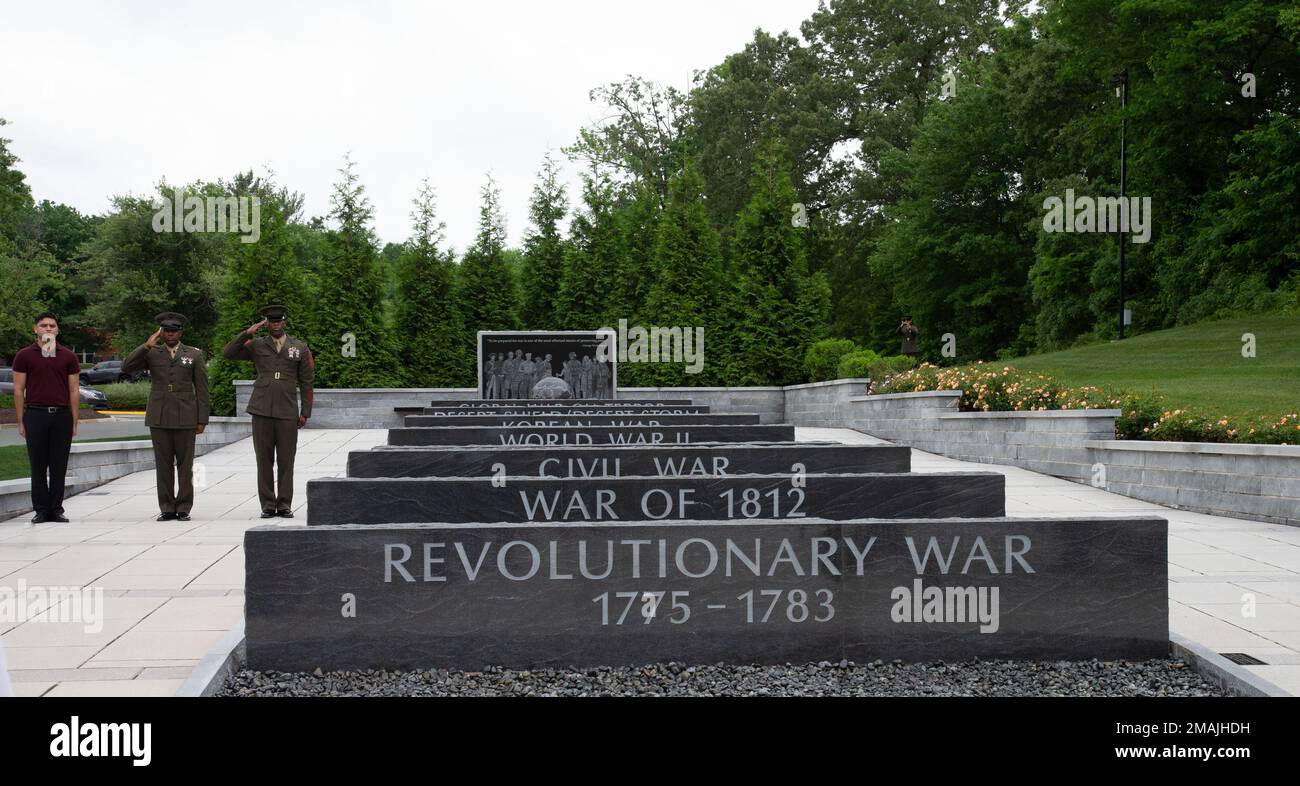 U.S. Marine Corps members render a hand salute during the playing of ...