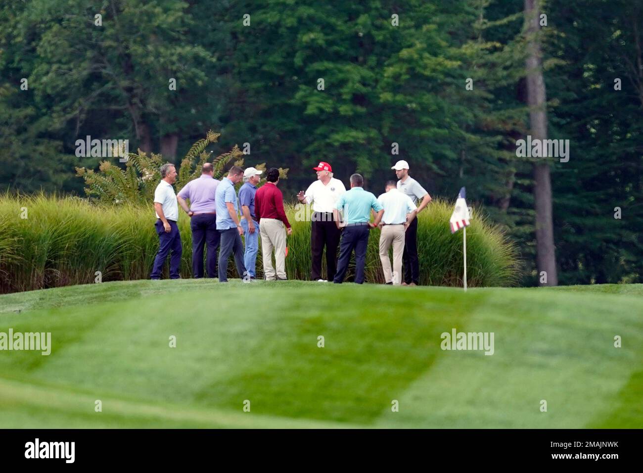 Former President Donald Trump, center, stands on his golf course with ...