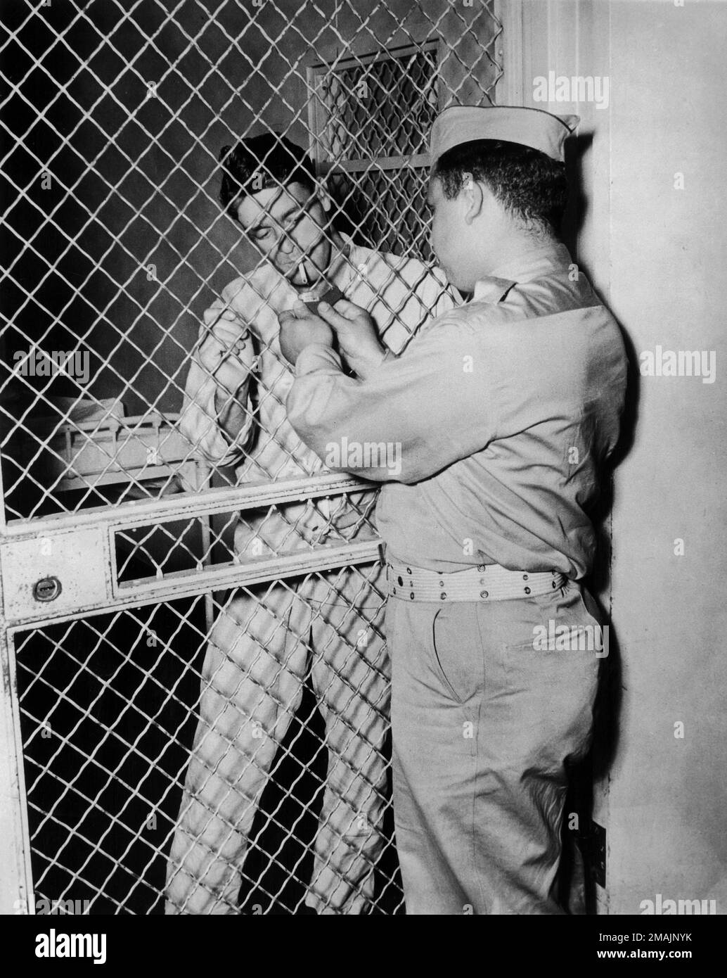 Pvt. Clarence V. Bertucci, left, of New Orleans, gets a light from his ...