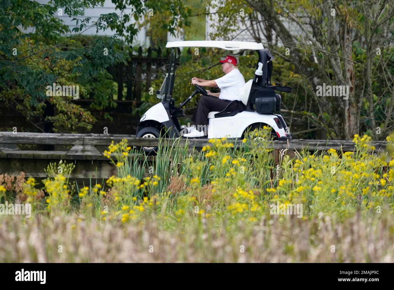 Former President Donald Trump rides around his golf course at Trump ...